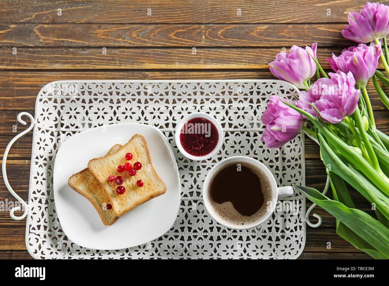 Beautiful tulips with tasty breakfast on wooden table Stock Photo - Alamy