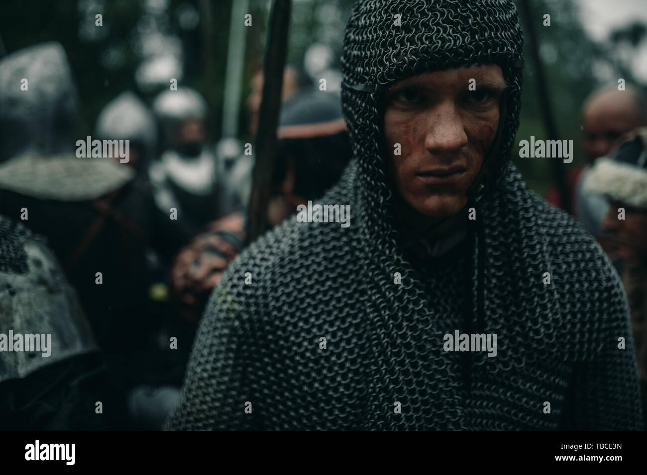 Portrait of young man in the image of a medieval knight in chain armor ...