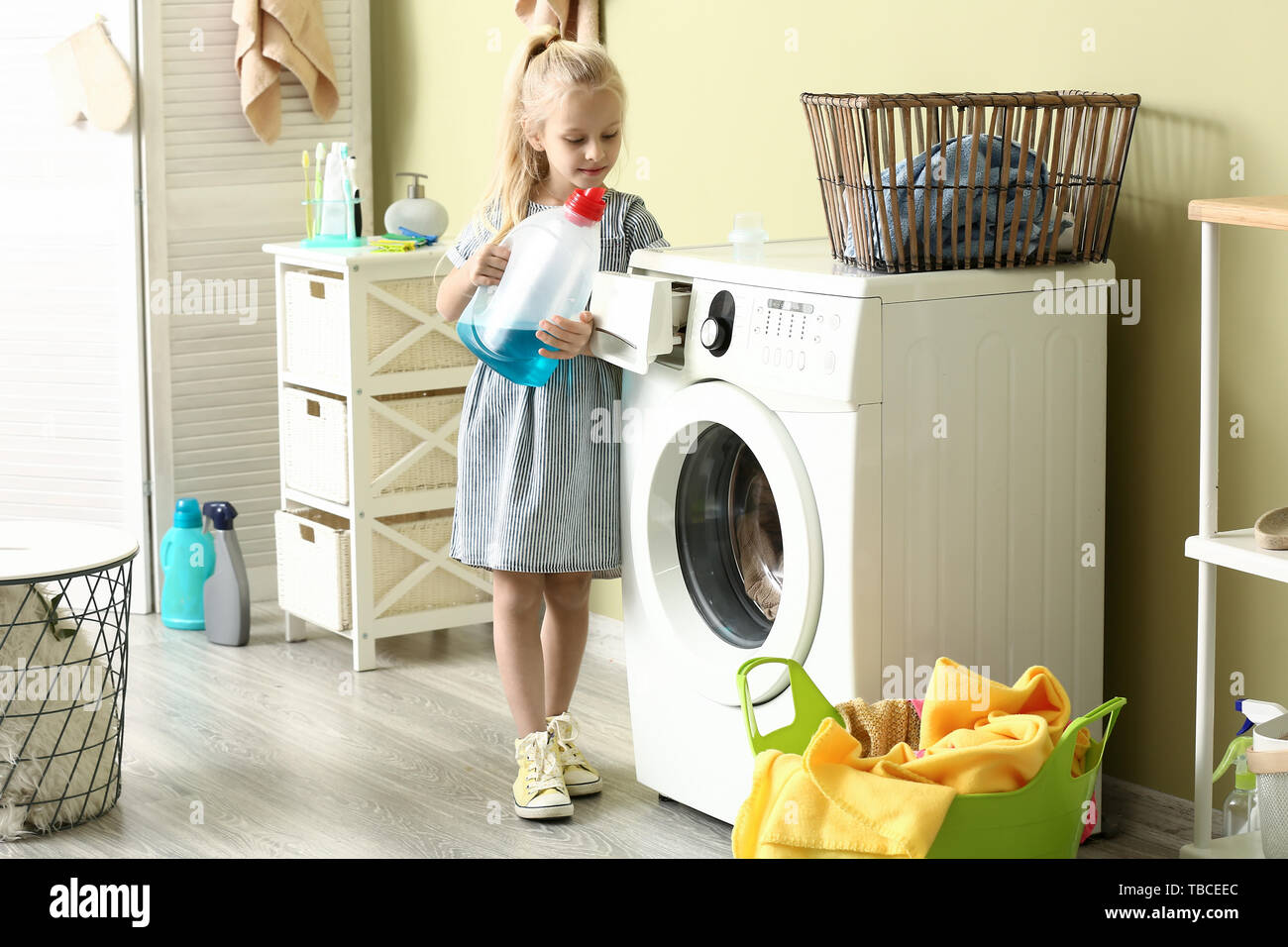 Little girl doing laundry at home Stock Photo - Alamy