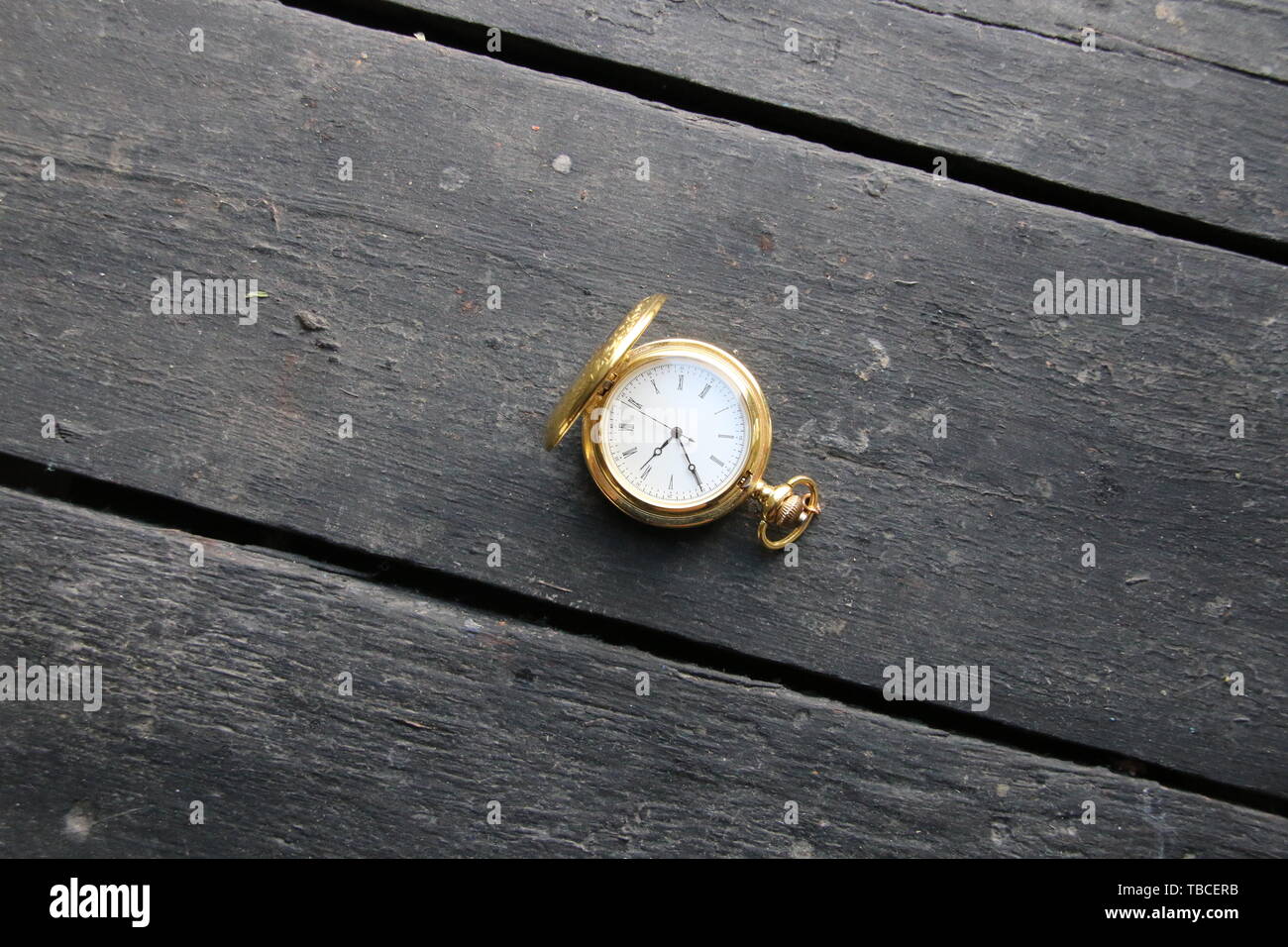 Vintage pocket watch lying on a vintage surface Stock Photo - Alamy