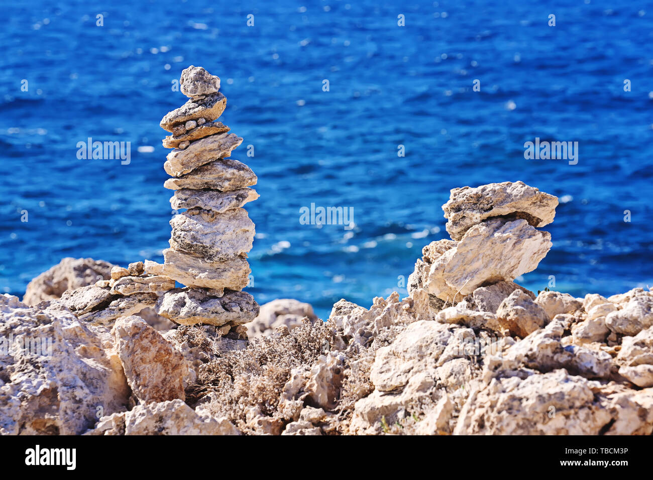 Zen pyramid of stacked rough stones on the blurred sea background ...