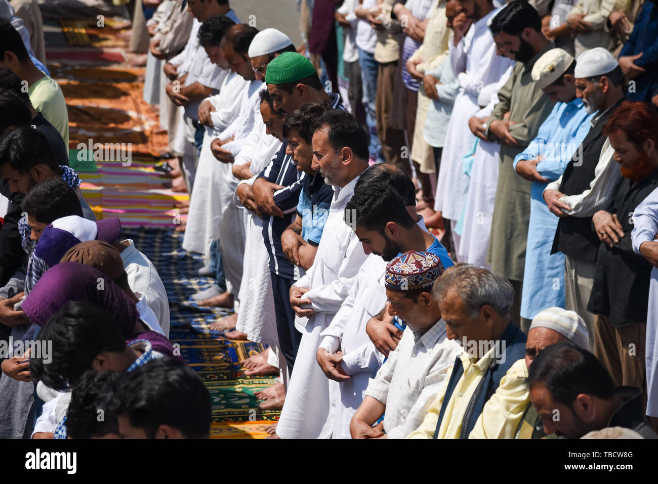 Kashmiri Muslims offer Prayers along a road outside Jamia masjid during ...