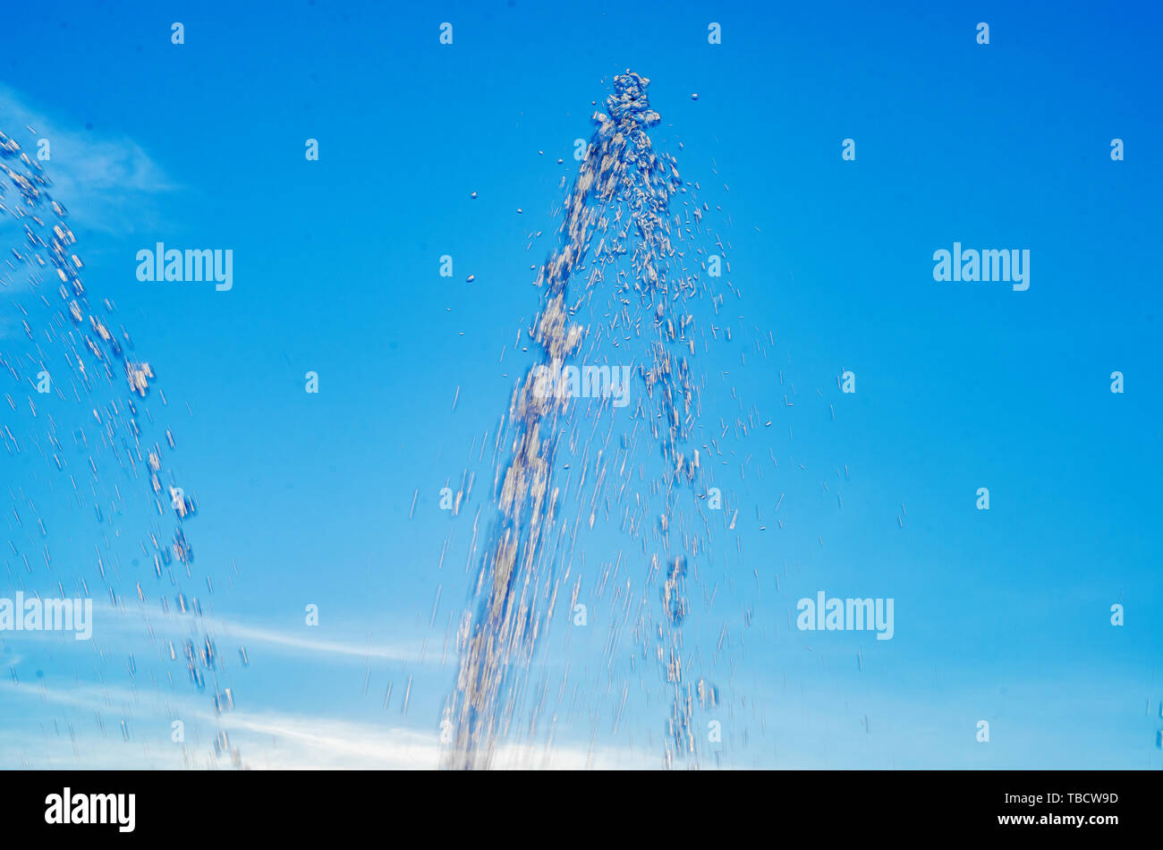 Water jet of fountain on blue sky background Stock Photo - Alamy