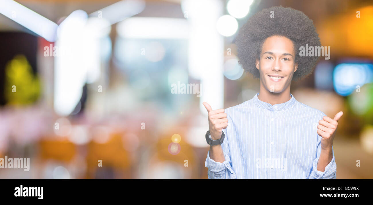 Young african american man with afro hair success sign doing positive ...