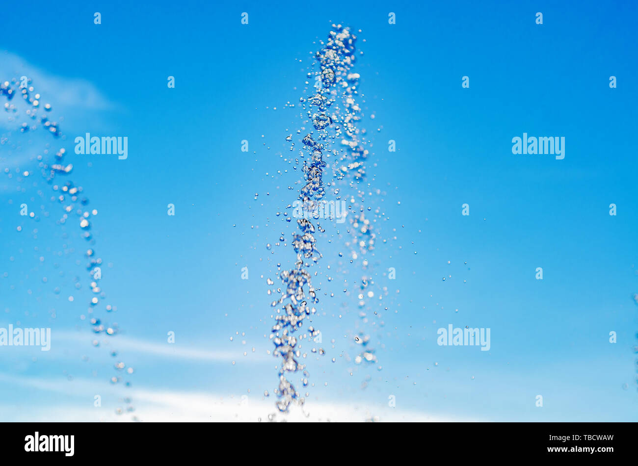 Water jet of fountain on blue sky background Stock Photo - Alamy