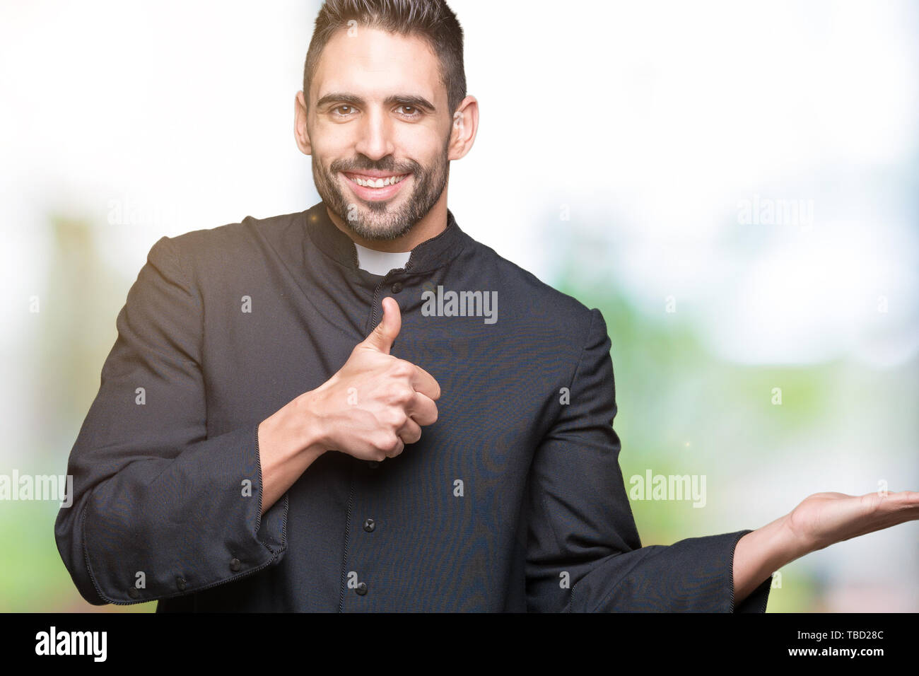 Young Christian priest over isolated background Showing palm hand and ...