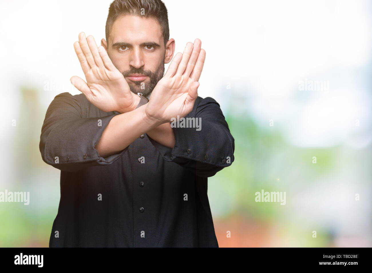 Young Christian priest over isolated background Rejection expression ...