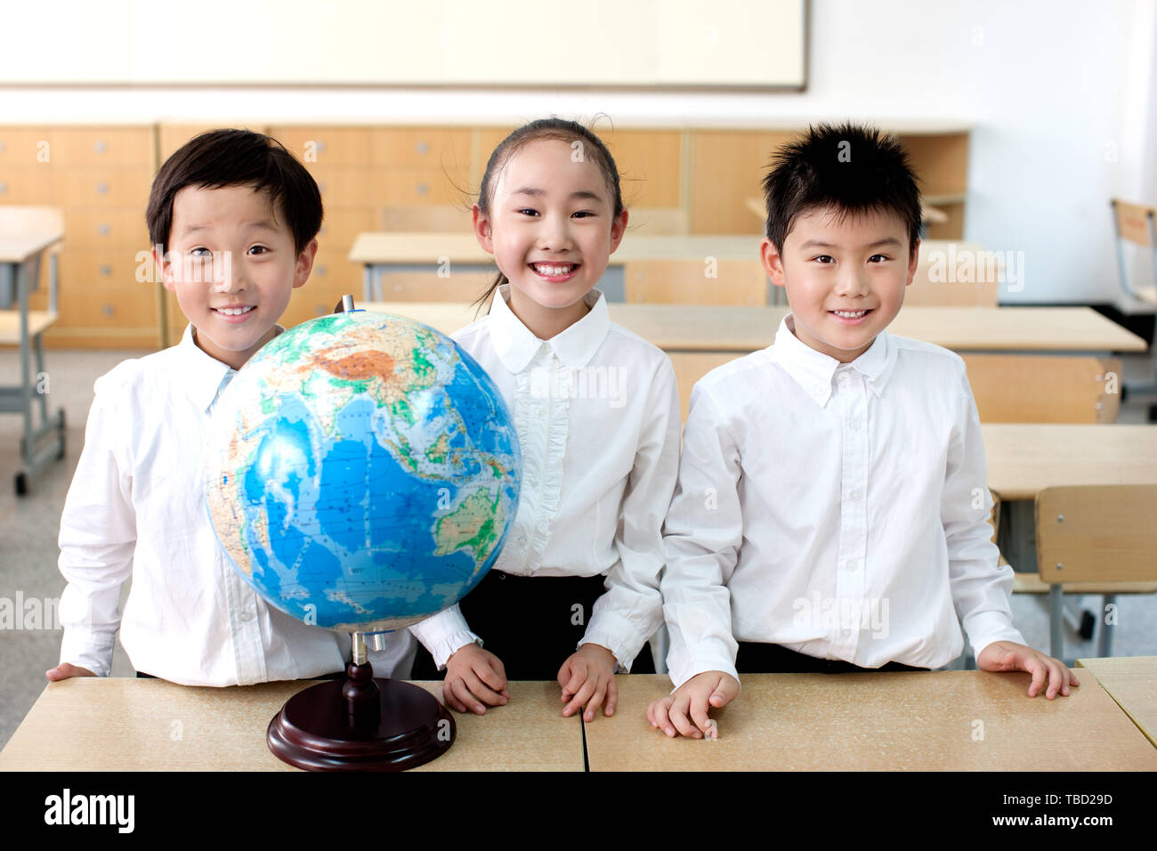 Three primary school students are in class in the classroom Stock Photo ...