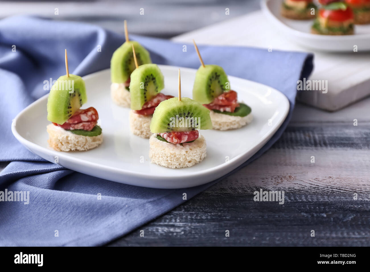 Plate with tasty canapes on wooden table Stock Photo - Alamy