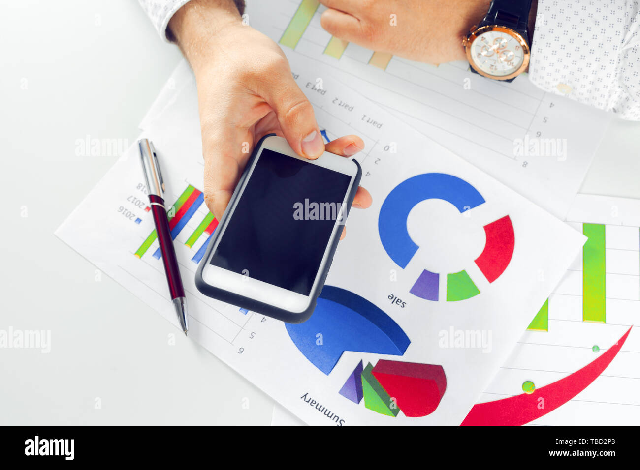 Man using smartphone over the office desk Stock Photo - Alamy
