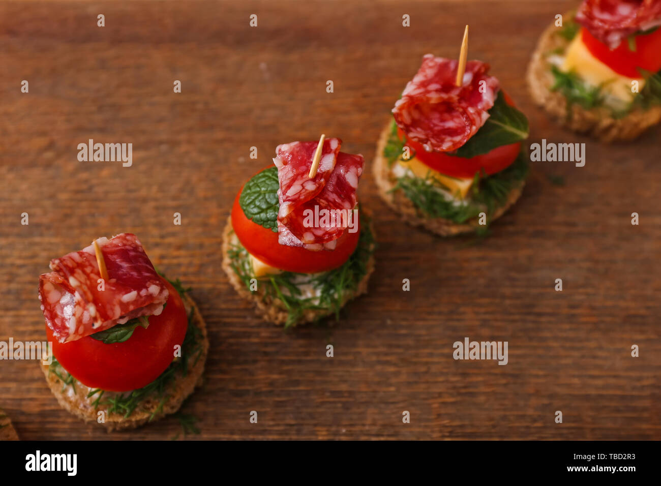 Tasty canapes on wooden background Stock Photo - Alamy