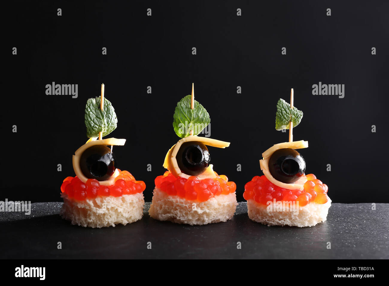 Tasty canapes on dark background Stock Photo - Alamy