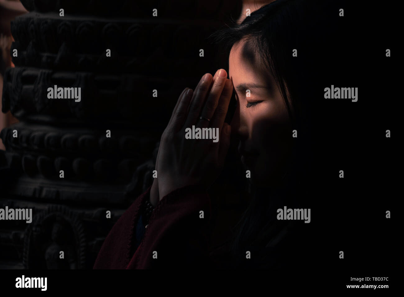 Devoted prayer in light and shadow Stock Photo - Alamy