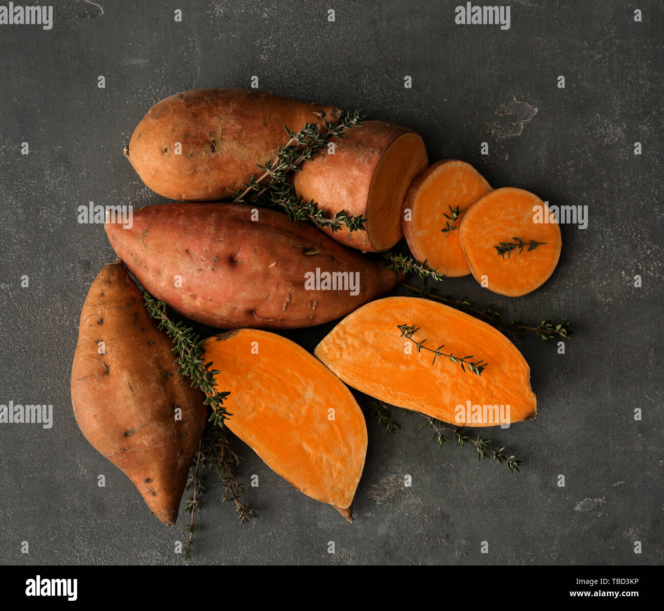 Raw sweet potato on grey table Stock Photo - Alamy