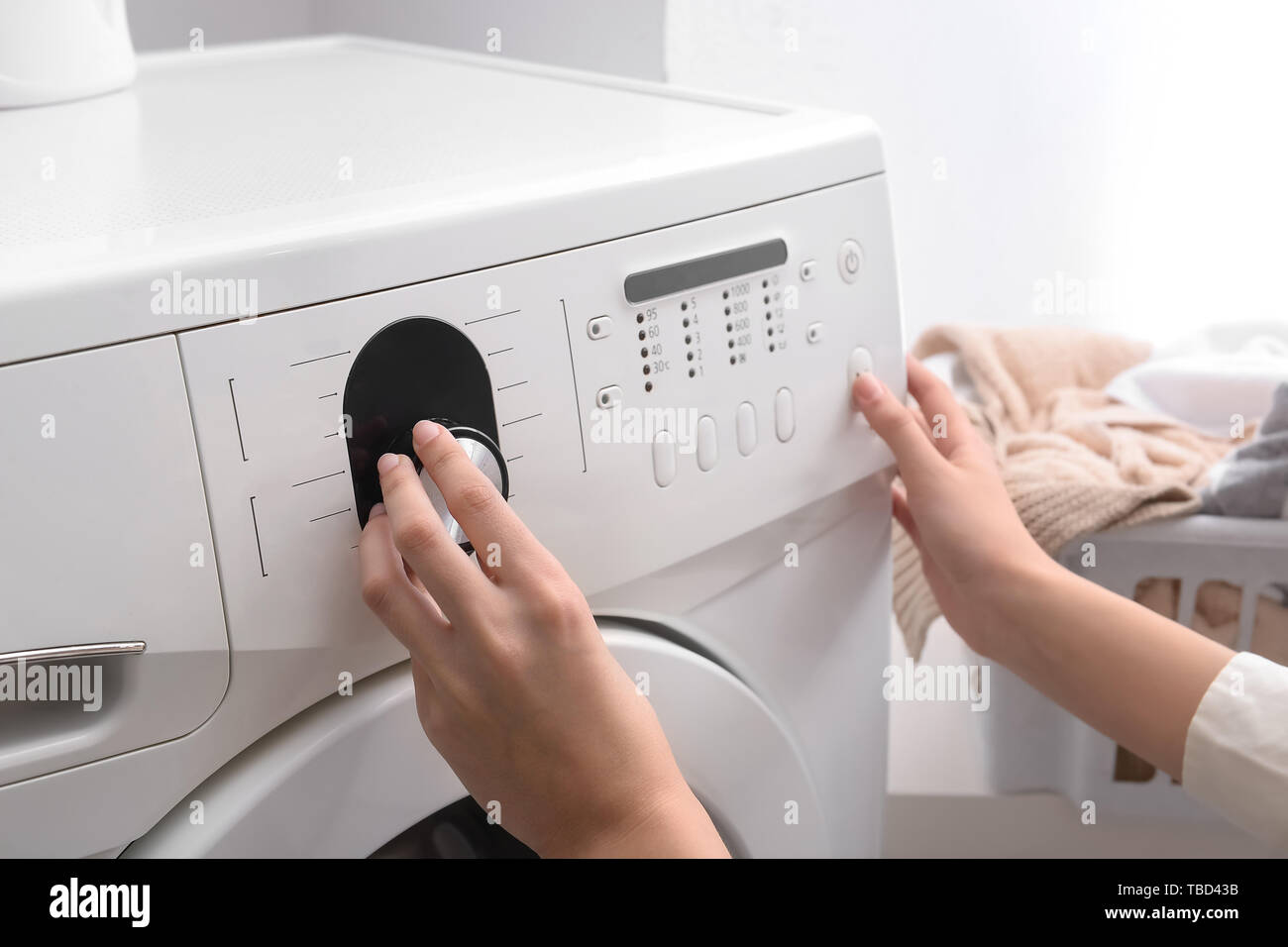 Woman switching on washing machine, closeup Stock Photo - Alamy