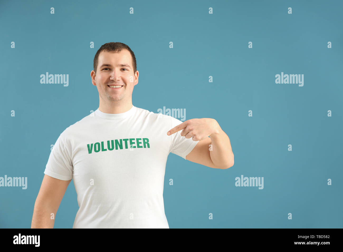 Young male volunteer on color background Stock Photo - Alamy