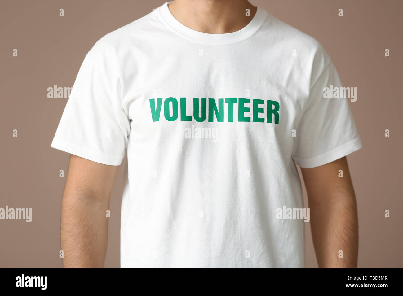 Young male volunteer on color background Stock Photo - Alamy