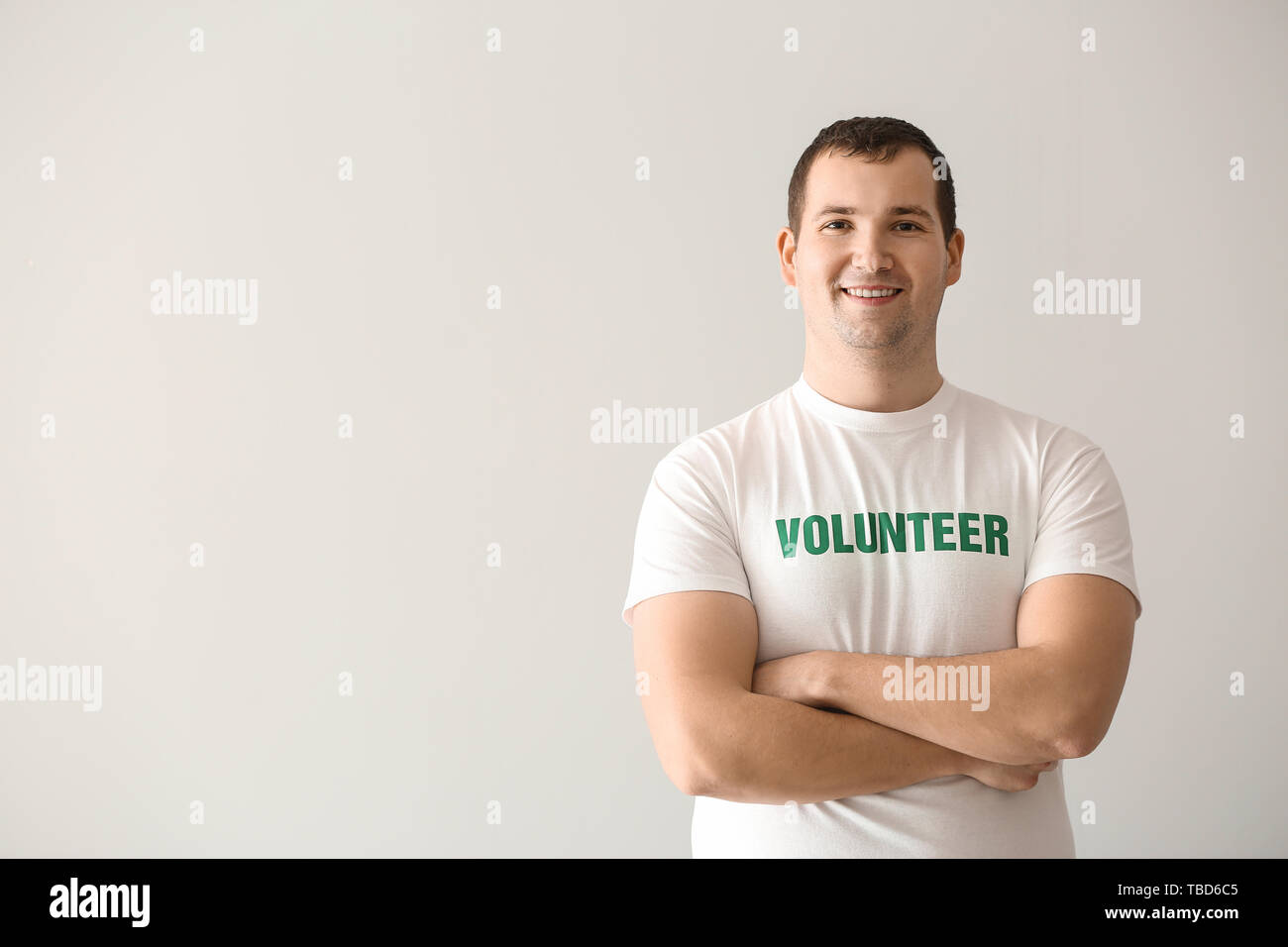 Young male volunteer on light background Stock Photo - Alamy