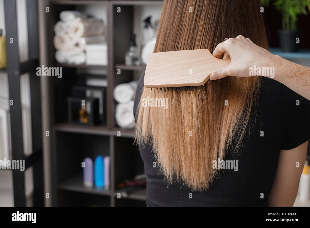 Hairdresser brushing long hair of young woman in salon Stock Photo - Alamy