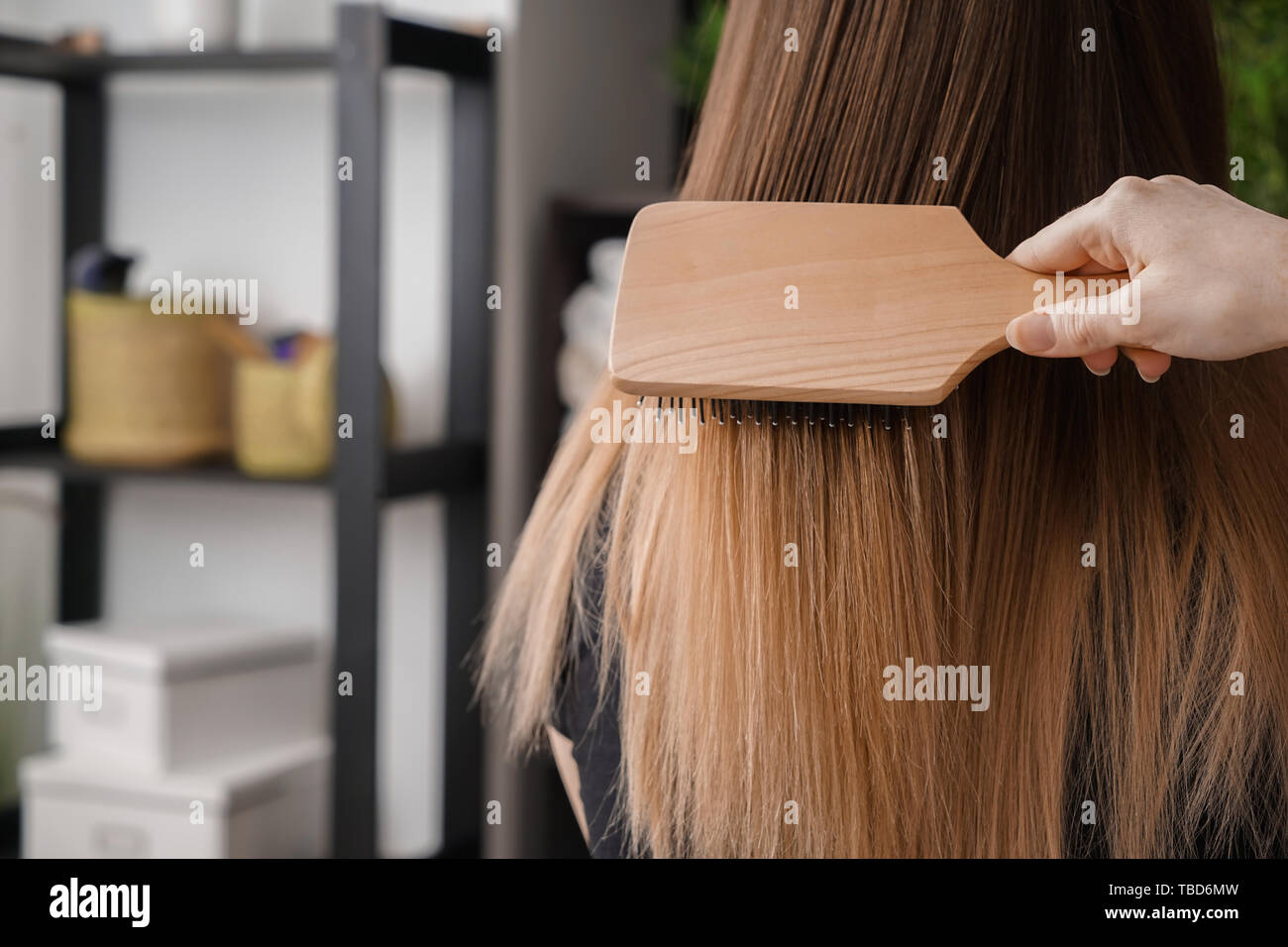 Hairdresser brushing long hair of young woman in salon Stock Photo - Alamy
