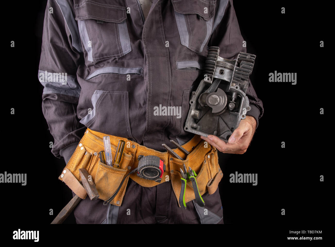 Mechanic with a small combustion engine in hand. A specialist in the ...