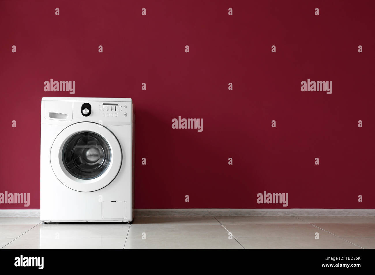 Modern washing machine near color wall Stock Photo - Alamy