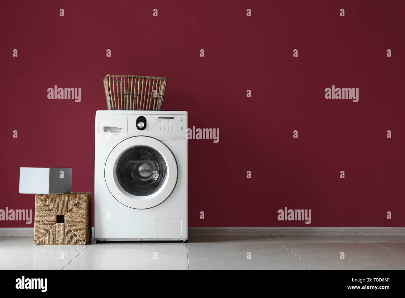 Modern washing machine and laundry near color wall Stock Photo - Alamy