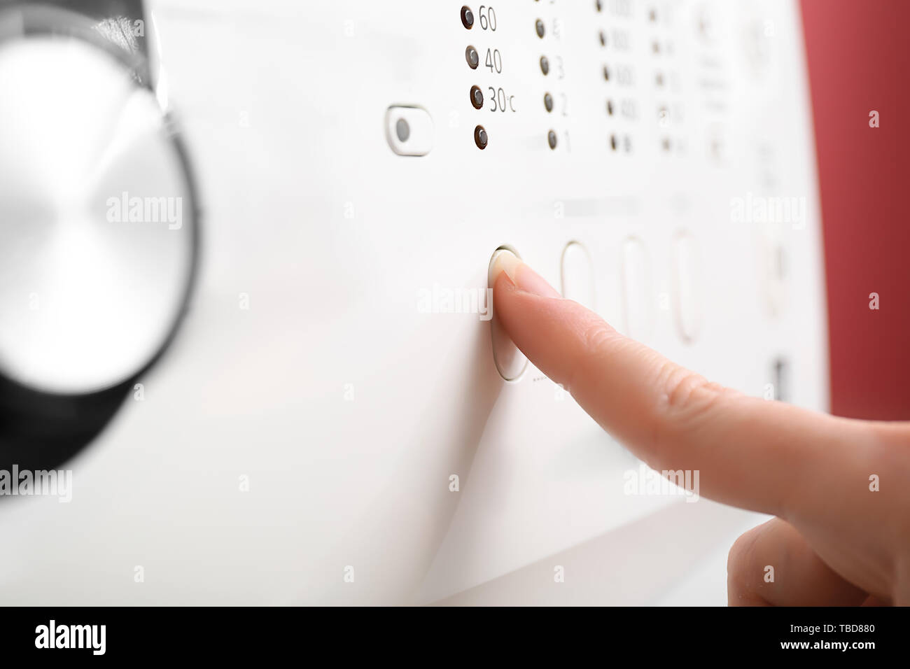 Woman adjusting washing machine before doing laundry, closeup Stock ...