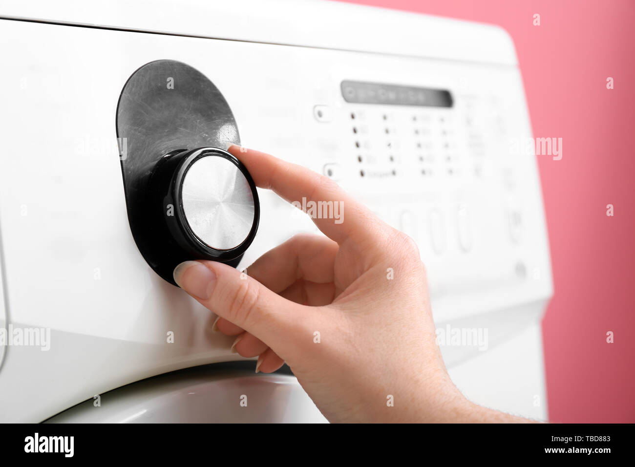 Woman adjusting washing machine before doing laundry, closeup Stock ...