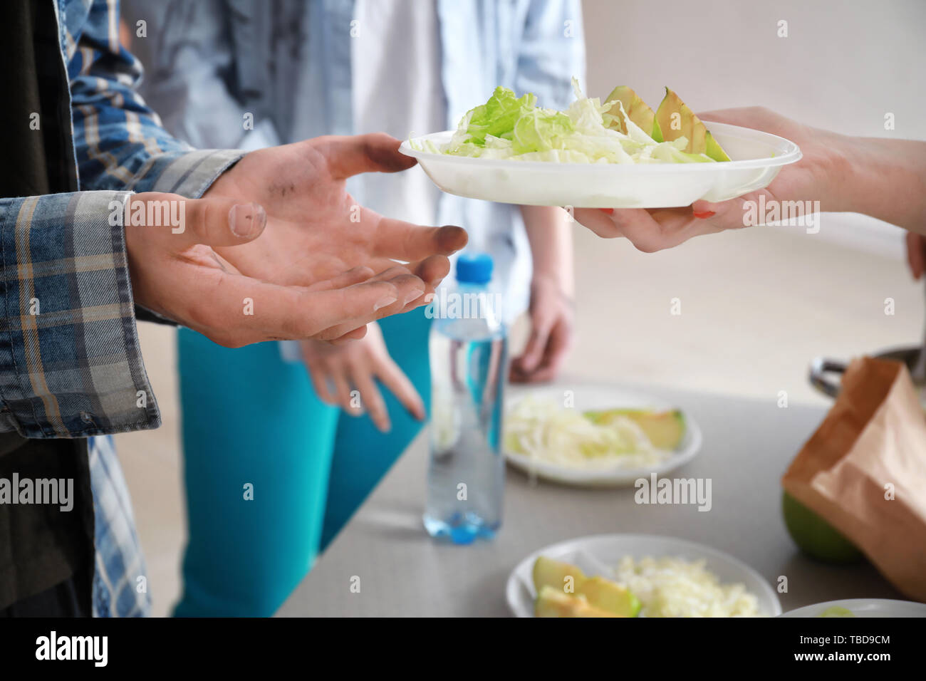 Young volunteers giving food to poor people Stock Photo - Alamy