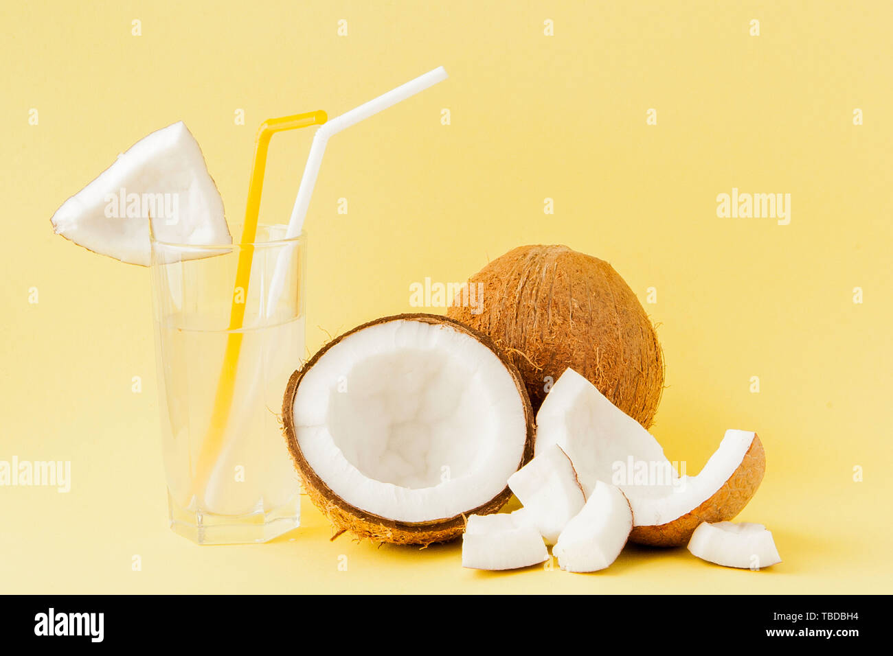 Fresh Coconut cocktail with a straws on yellow background, copy space ...