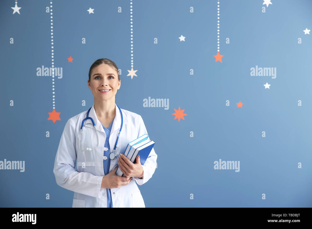 Female doctor with books on color background Stock Photo - Alamy