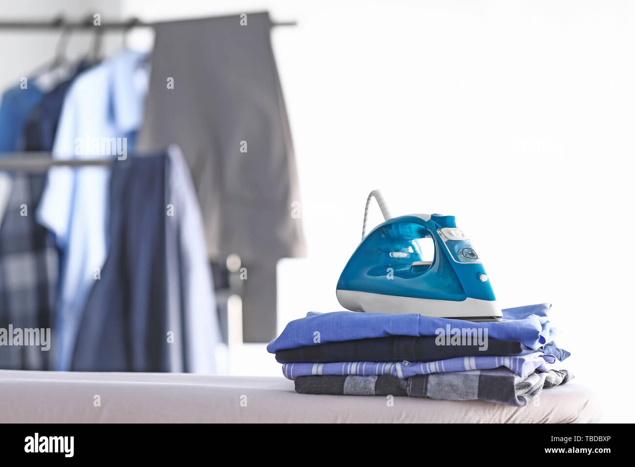 Iron with clean clothes on board Stock Photo - Alamy