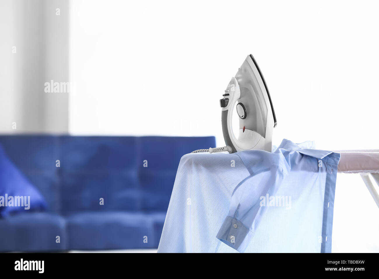 Iron with clean clothes on board Stock Photo - Alamy