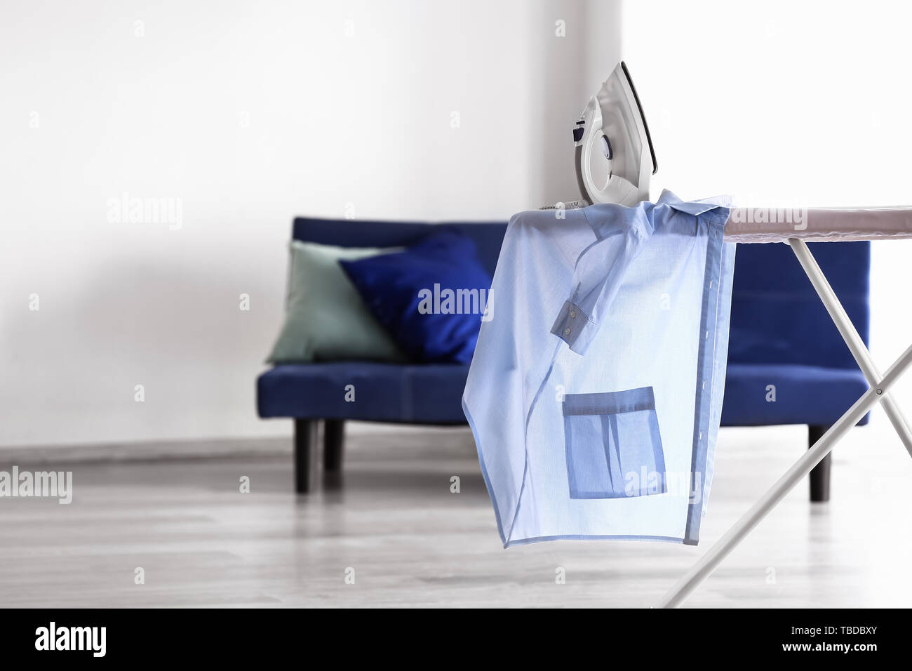 Iron with clean clothes on board Stock Photo - Alamy