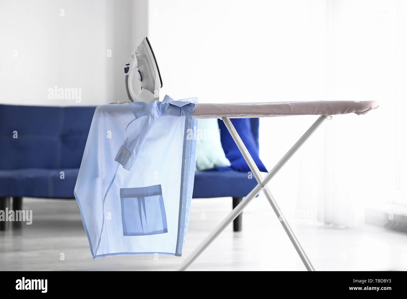 Iron with clean clothes on board Stock Photo - Alamy