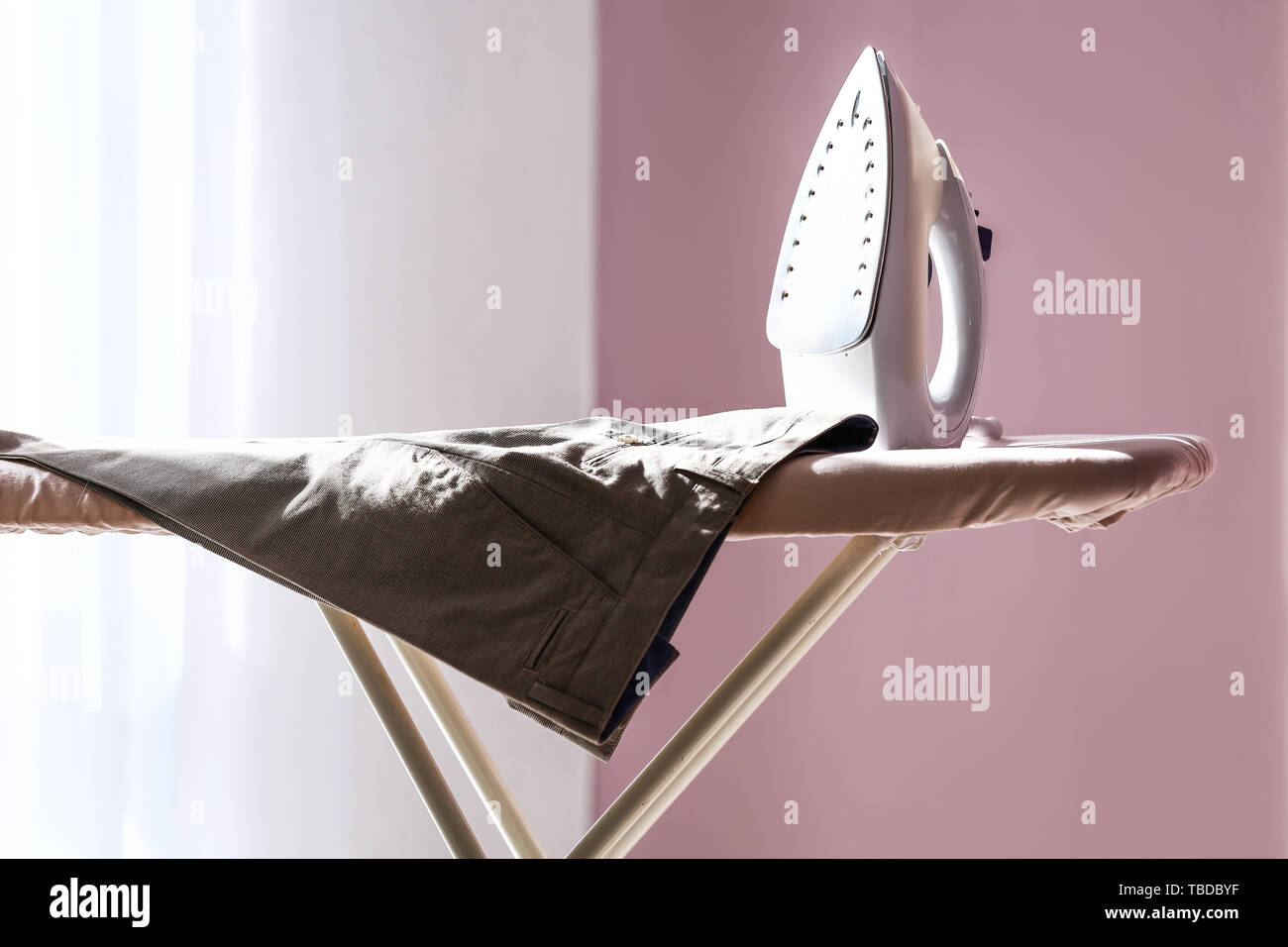 Iron with clean clothes on board Stock Photo - Alamy
