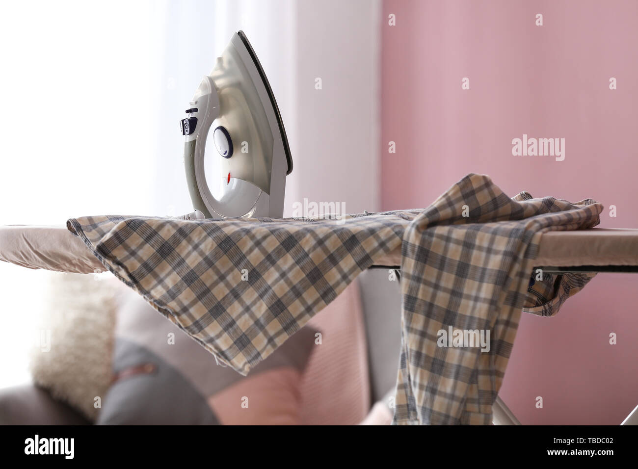 Iron with clean clothes on board Stock Photo - Alamy