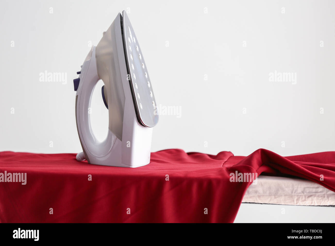 Iron with clean clothes on board Stock Photo - Alamy