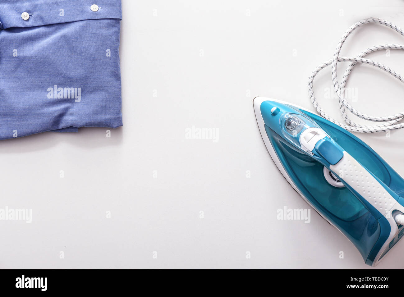 Iron with clean clothes on white background Stock Photo - Alamy
