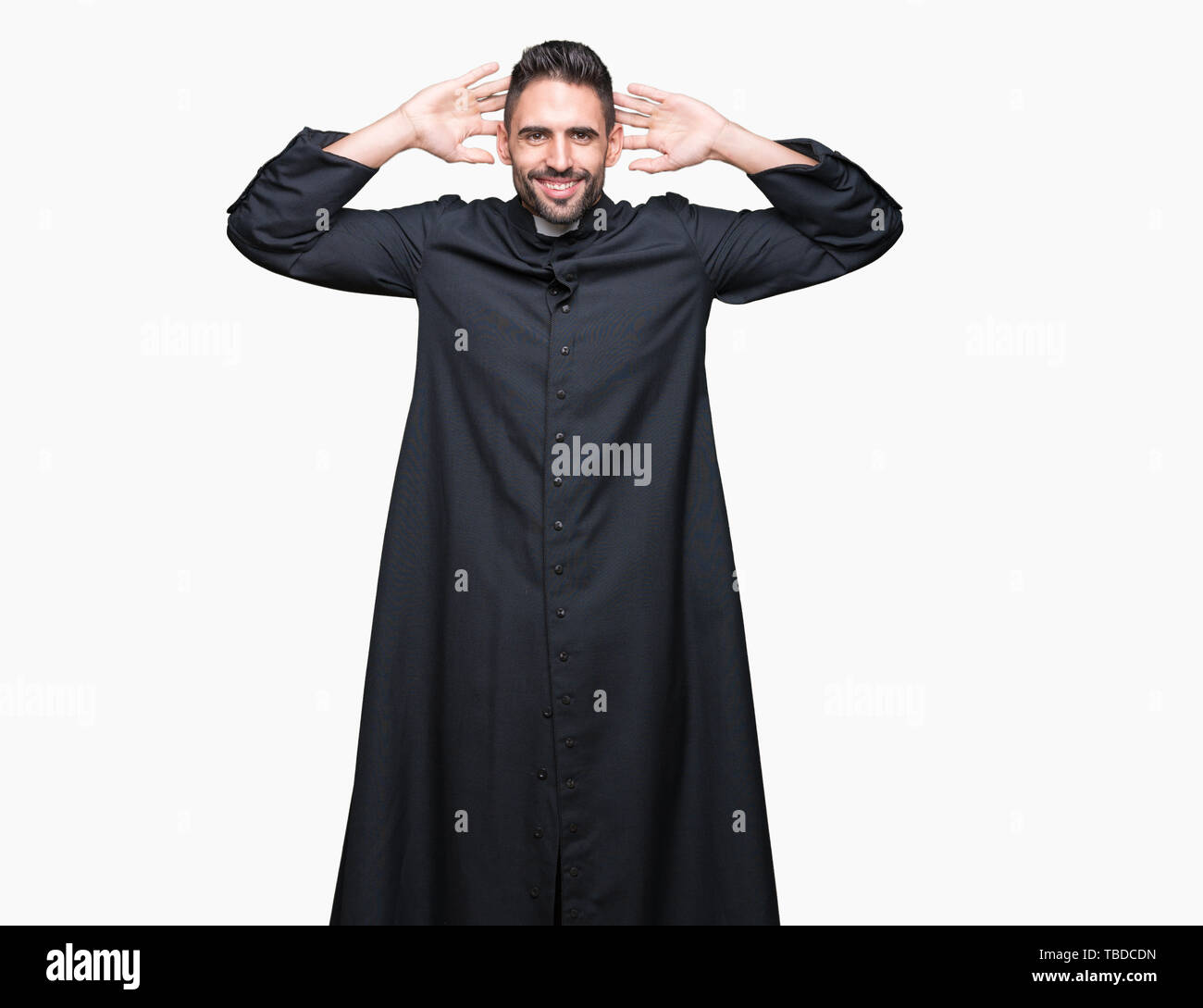 Young Christian priest over isolated background Relaxing and stretching ...