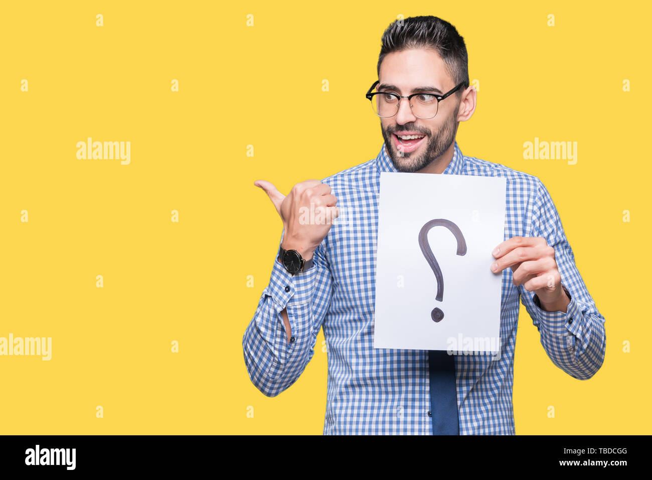 Handsome young business man holding paper with question mark over ...