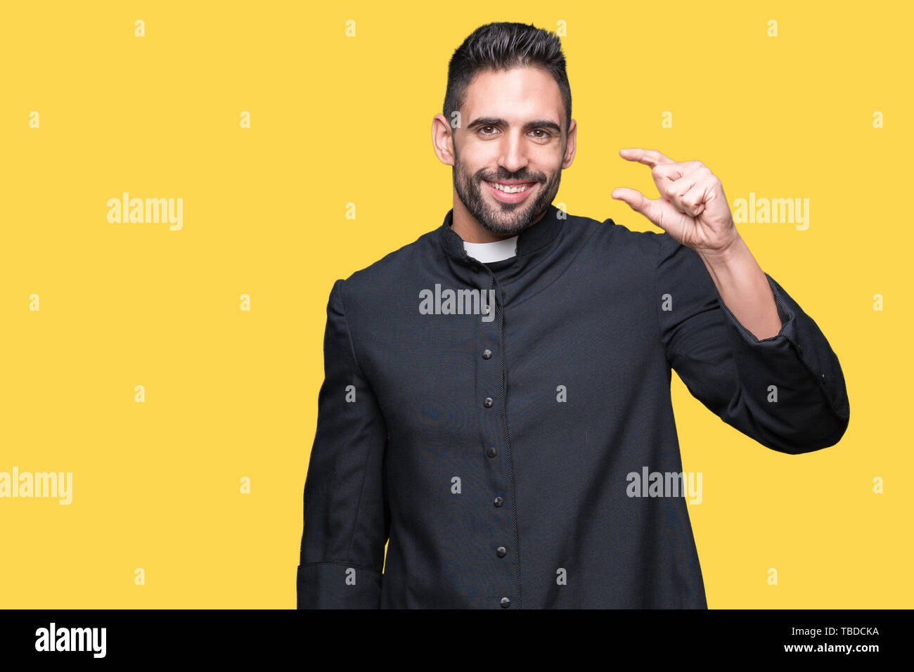 Young Christian priest over isolated background smiling and confident ...