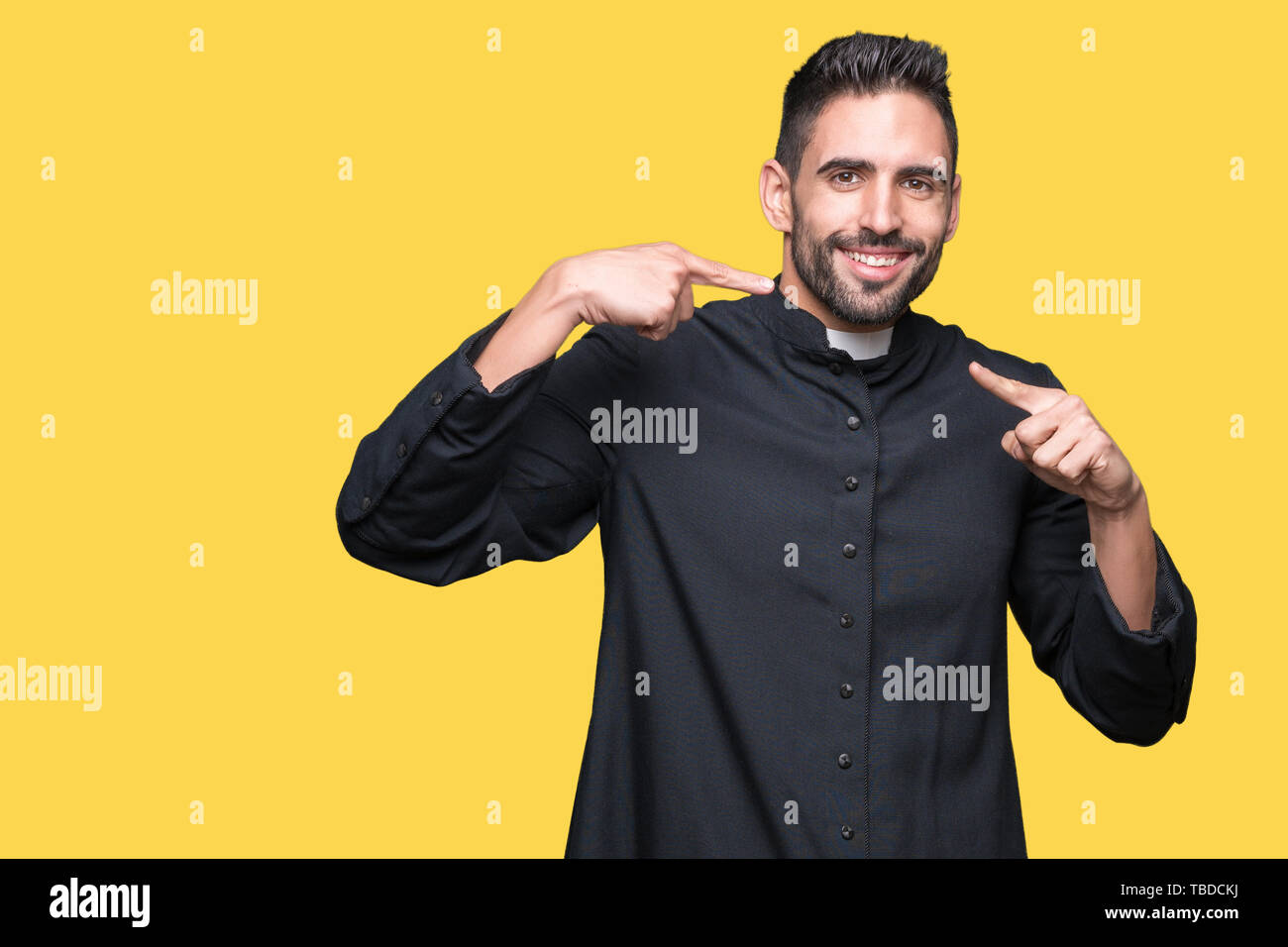 Young Christian priest over isolated background smiling confident ...