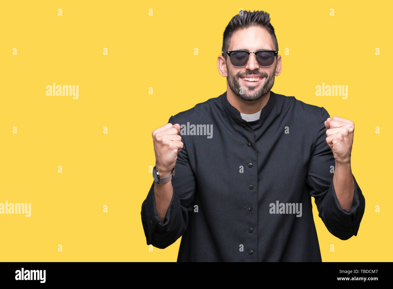 Young Christian priest wearing sunglasses over isolated background ...