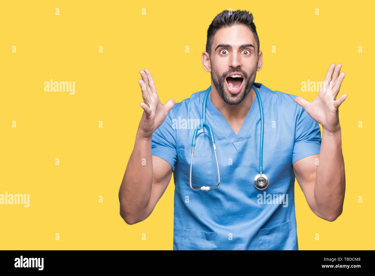 Handsome young doctor surgeon man over isolated background celebrating ...