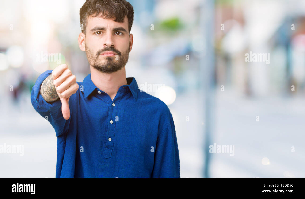 Young handsome man over isolated background looking unhappy and angry ...