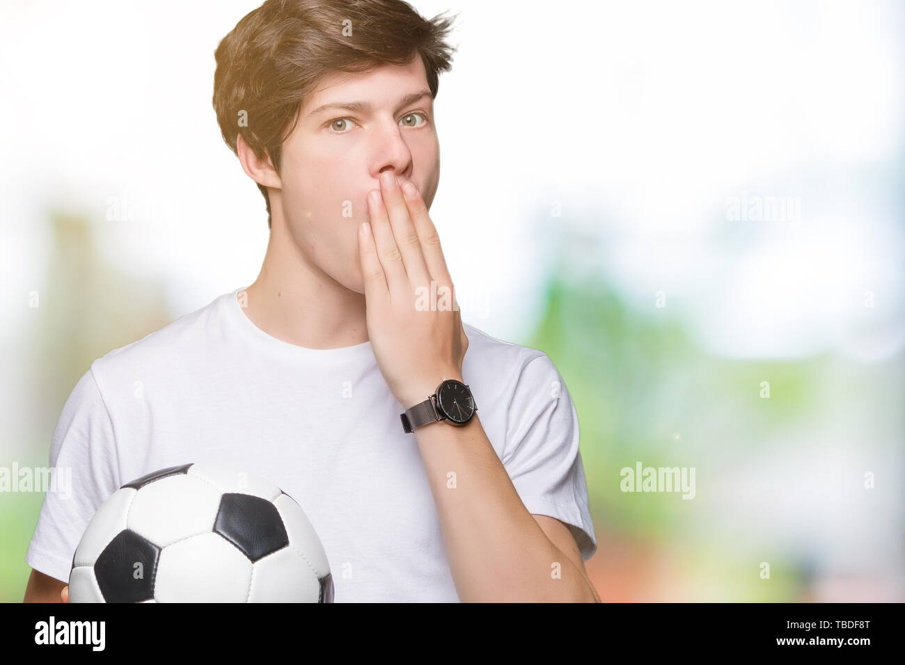Young man holding soccer football ball over isolated background cover ...