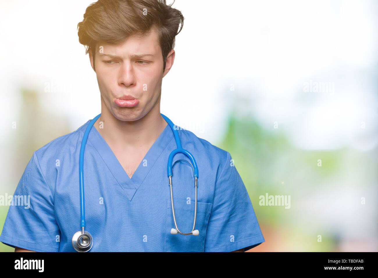 Young doctor wearing medical uniform over isolated background depressed ...