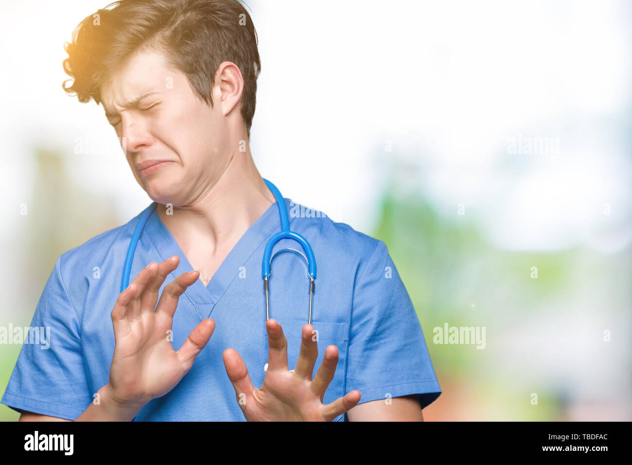 Young doctor wearing medical uniform over isolated background disgusted ...